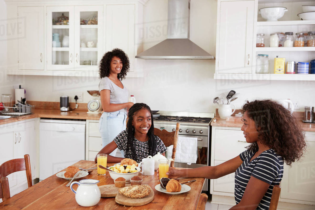 Family With Teenage Children Eating Breakfast In Kitchen - Royalty-free ...
