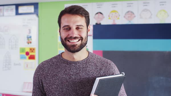 Portrait Of Male Elementary School Teacher Standing In Classroom - 4K ...