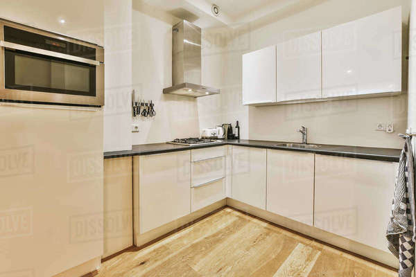 Modern home kitchen corner interior design with white cupboards and ...