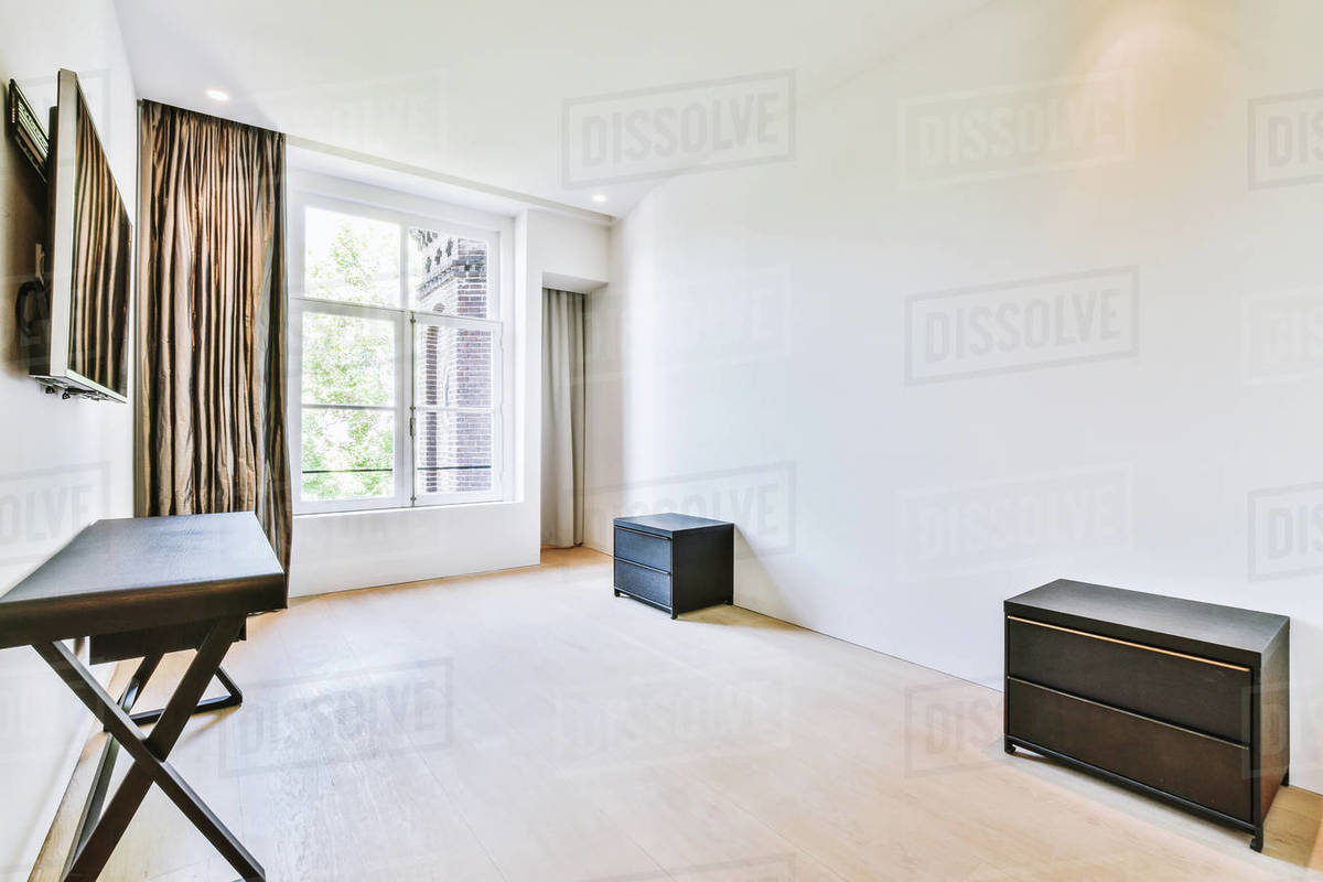Interior of spacious room with chests of drawers in apartment designed ...