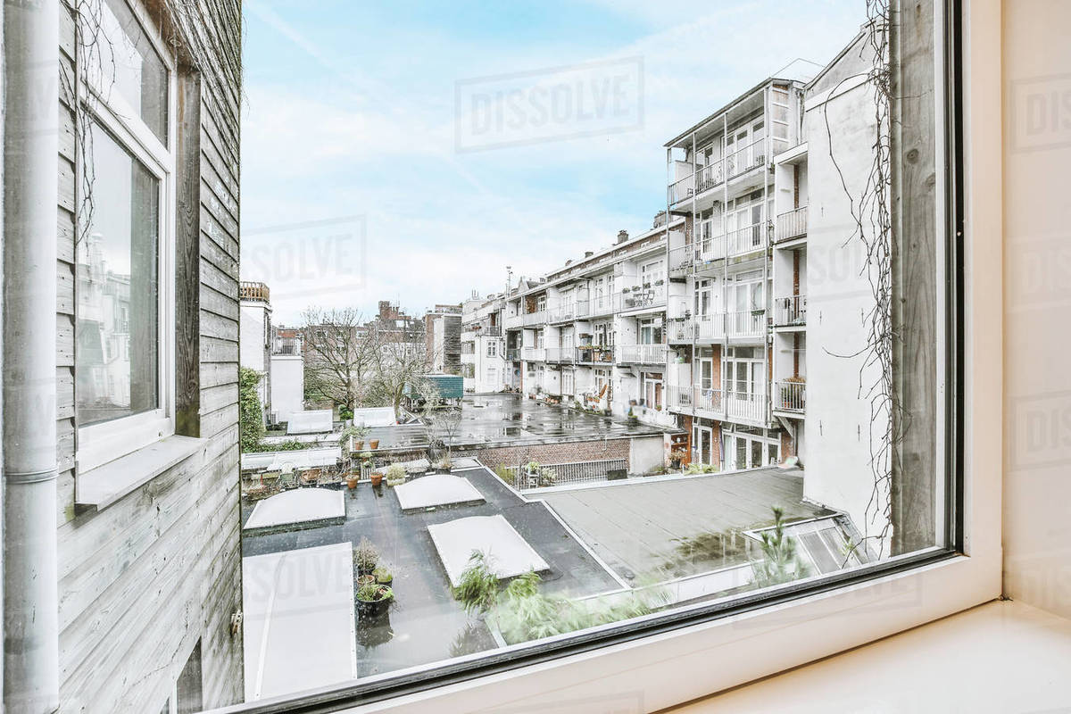 Through window view of city district with residential apartment ...