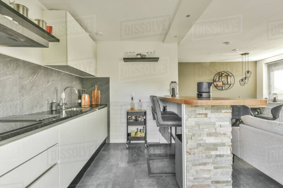 Luxury kitchen in shades of gray with a worktop and high-legged chairs ...
