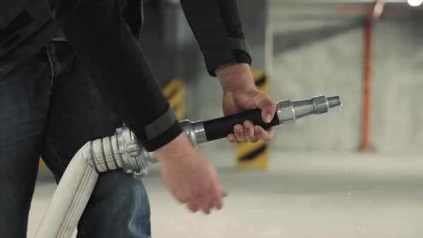 The fireman closes the fire hydrant. Fire fighting Opening the faucet ...