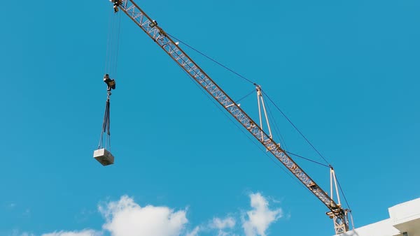 A construction crane moves cargo on a construction site. A crane moves ...