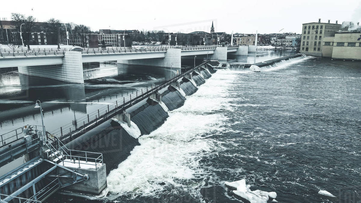 Water flows from the reservoir through the open dam with bridge ...