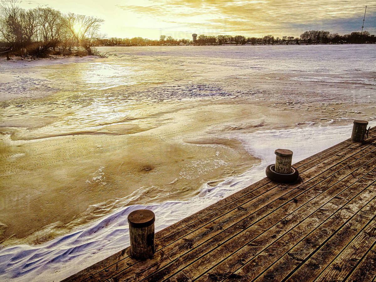 Perspective from the pier watching the sunrise over the frozen lake ...