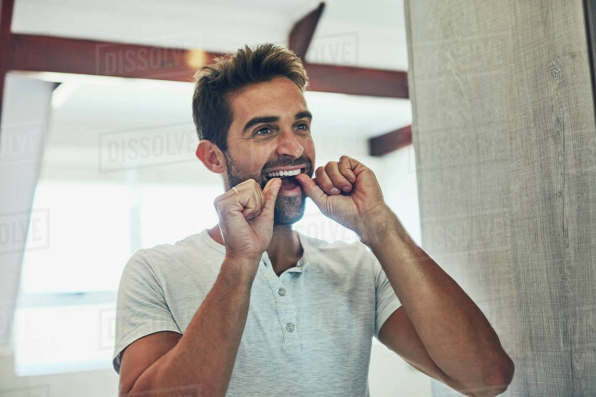 Dental, floss and teeth with man in bathroom mirror for cleaning, morning routine and oral ...