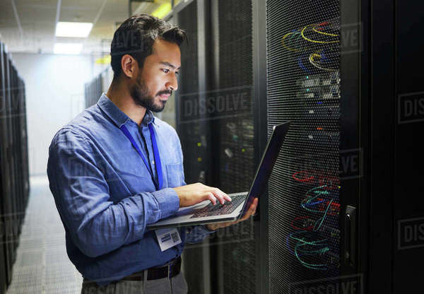 Man, engineering laptop and data center, server room inspection or ...