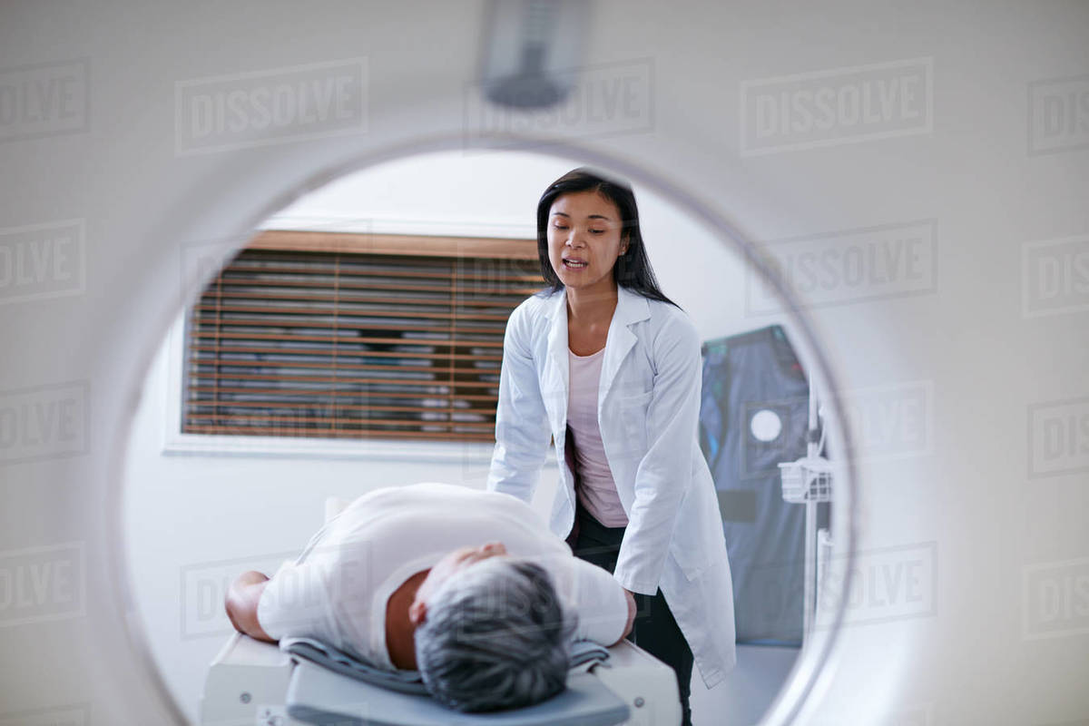 Doctor, mri and woman with patient in hospital ready to start scanner ...