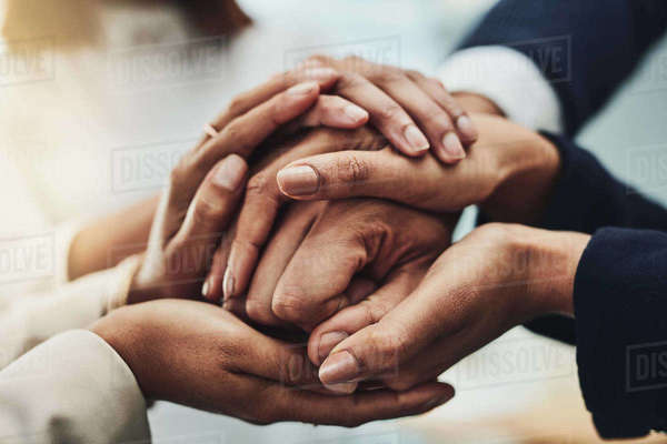Business people holding hands for support, motivation and comfort ...