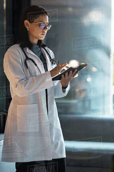 Doctor, tablet and woman planning at night in medical office, hospital ...
