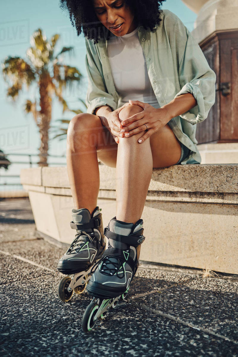 Knee pain, roller skater injury and woman in city after accident or ...