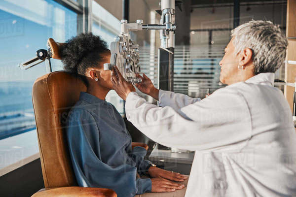 Vision test, eye exam and black woman with optometrist for testing ...