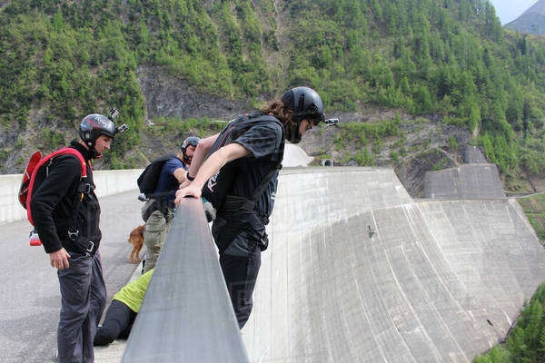 Base jumper standing on the ledge of the Contra dam in Ticino canton ...
