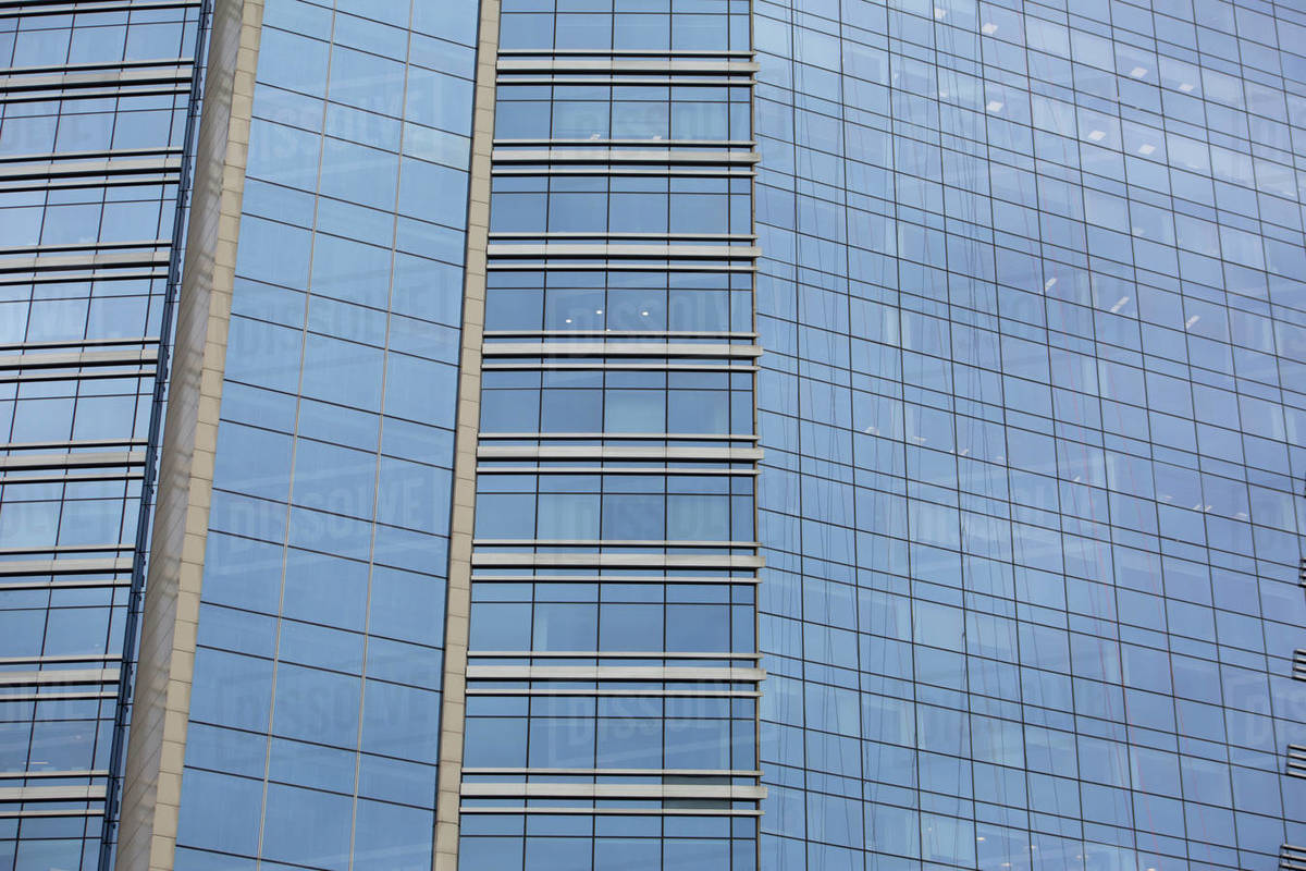 Glass facade of skyscraper with office space. Modern blue glass ...