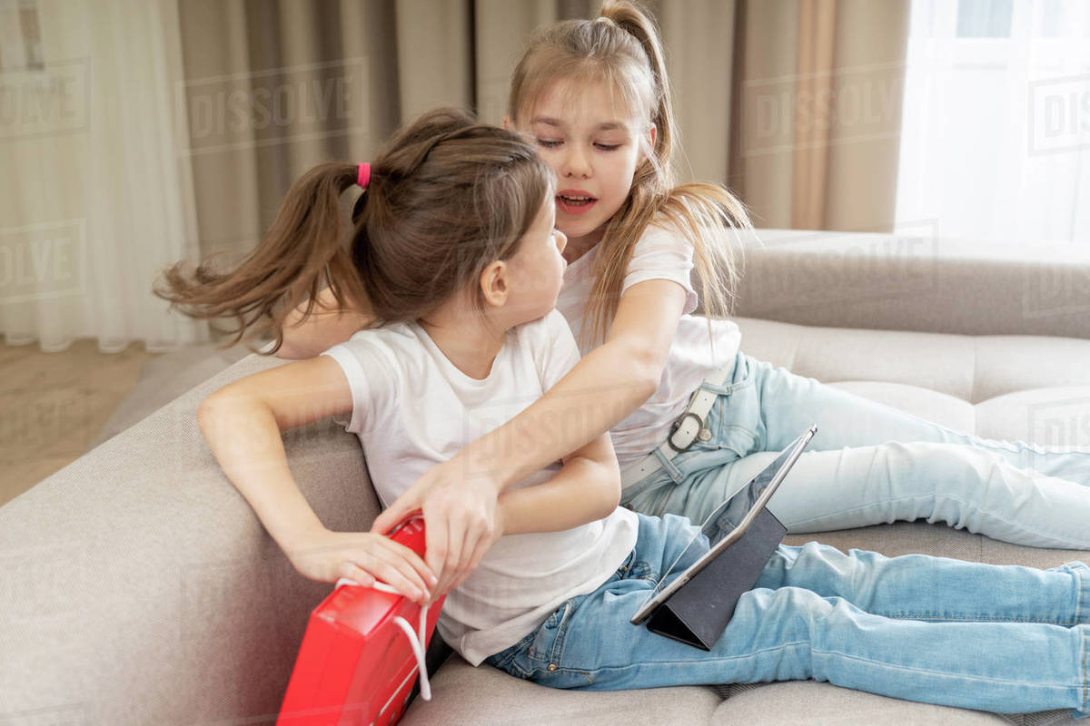 The present is mine. Little girls fight over present box. Giving ...