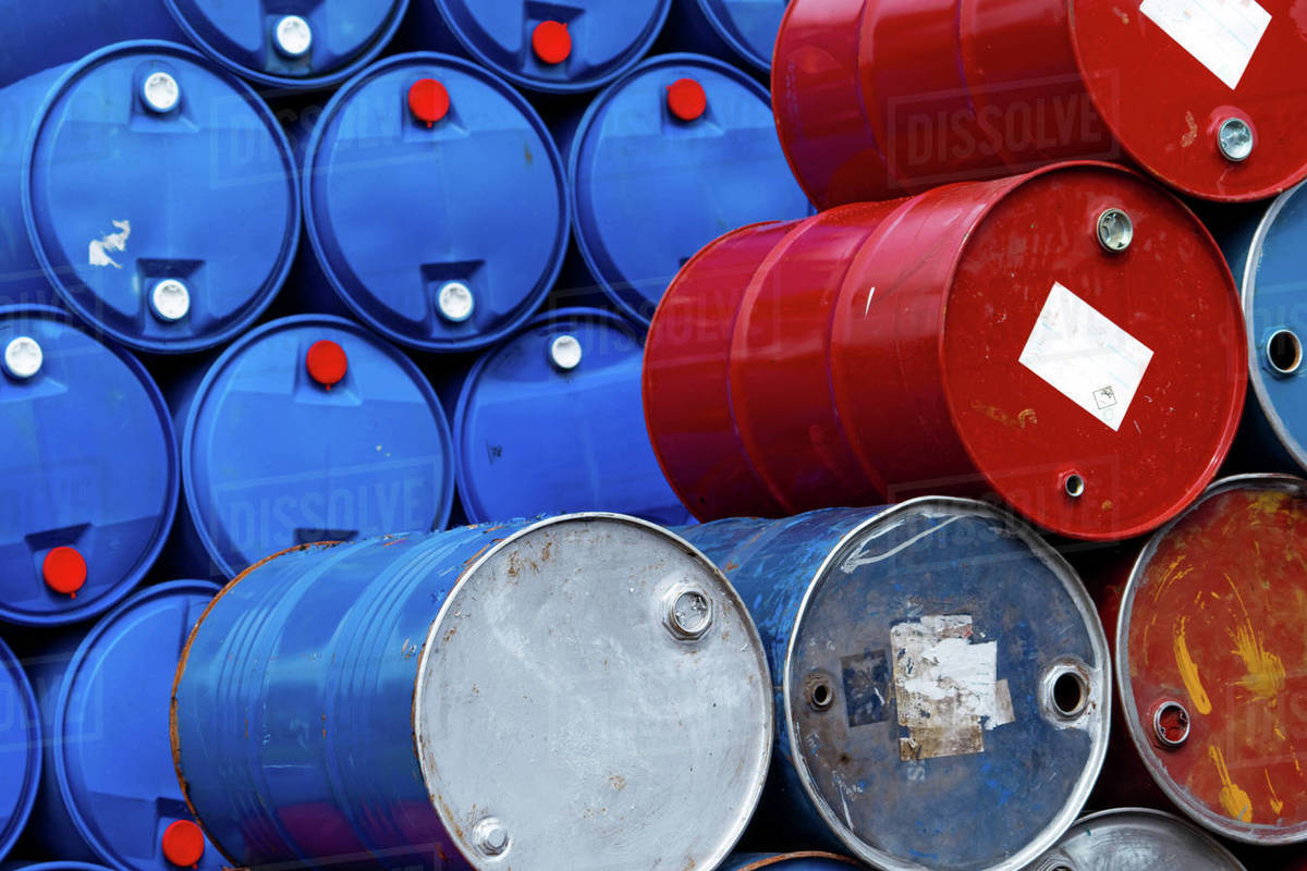 Old chemical barrel. Blue and red oil drum. Steel and plastic oil tank ...