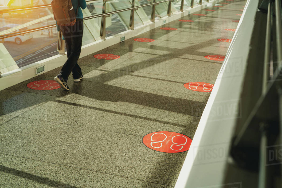 Back view of woman walking on pedestrian glass bridge. Corridor ...
