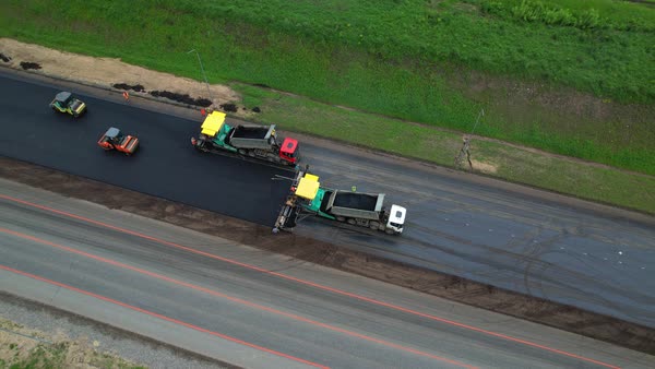 Road construction works aerial view. Laying of new asphalt on the road ...