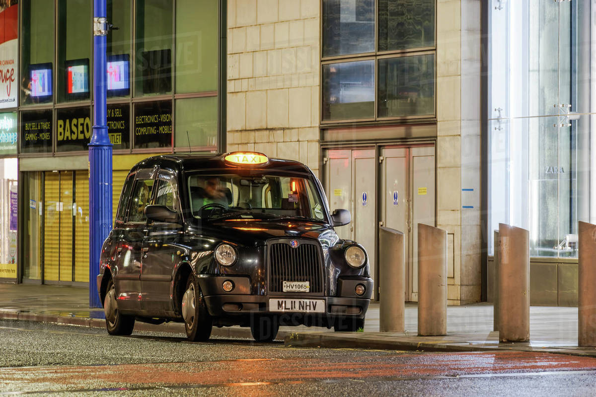Manchester, UK black traditional taxi with driver and illuminated free ...