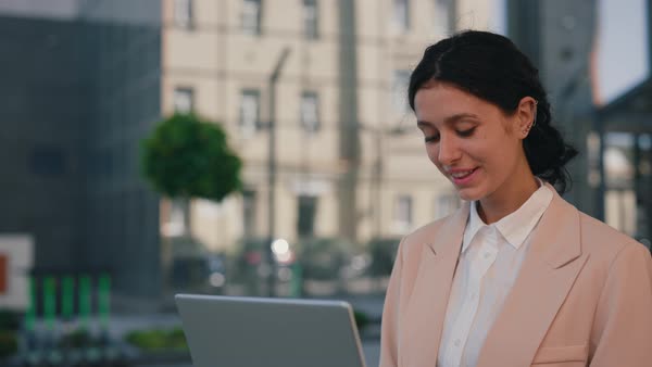 Smiling beautiful business woman sitting, working outdoors, using ...