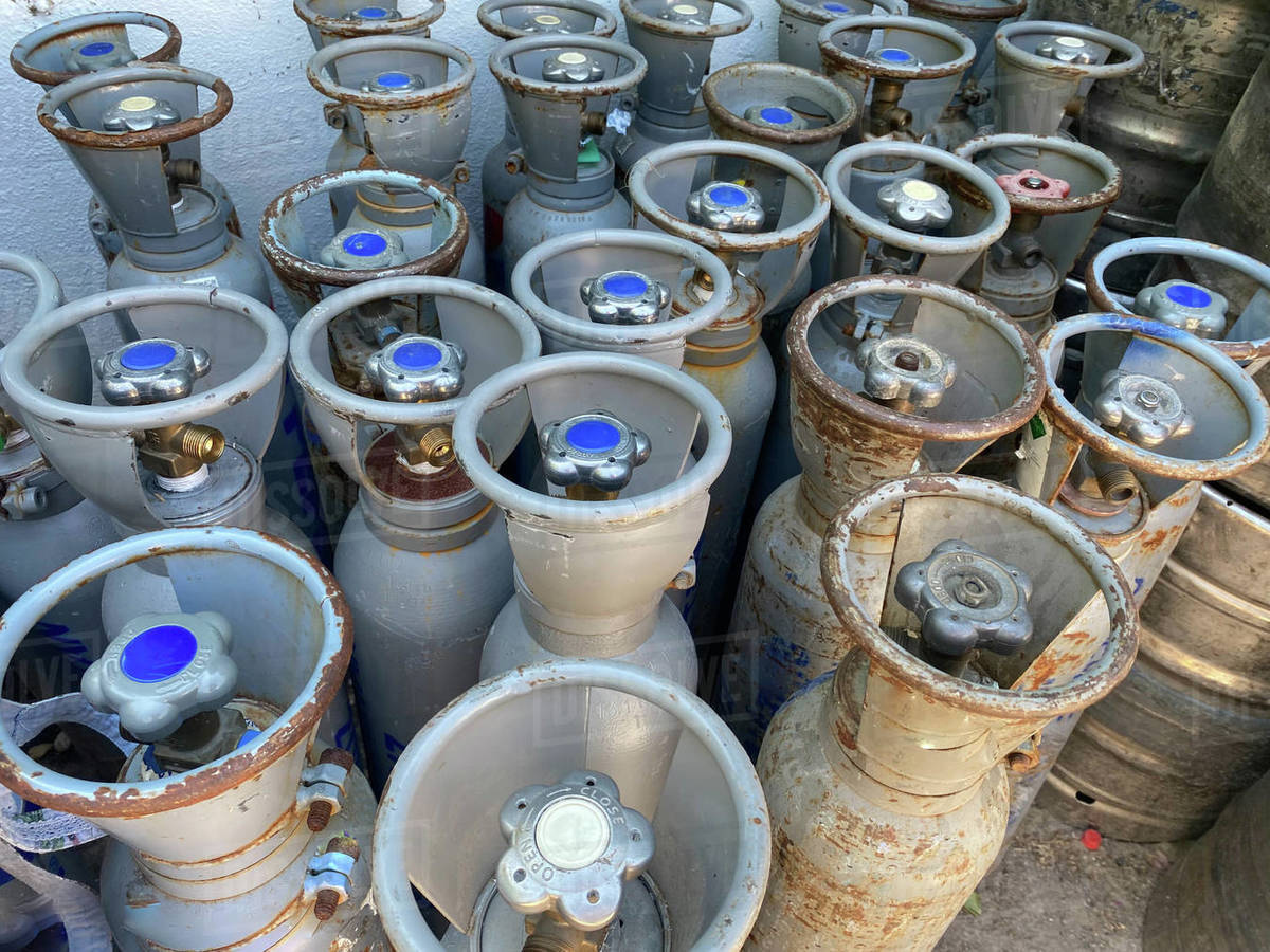 Many oxygen cylinders and argon cylinders with compressed gas secured ...