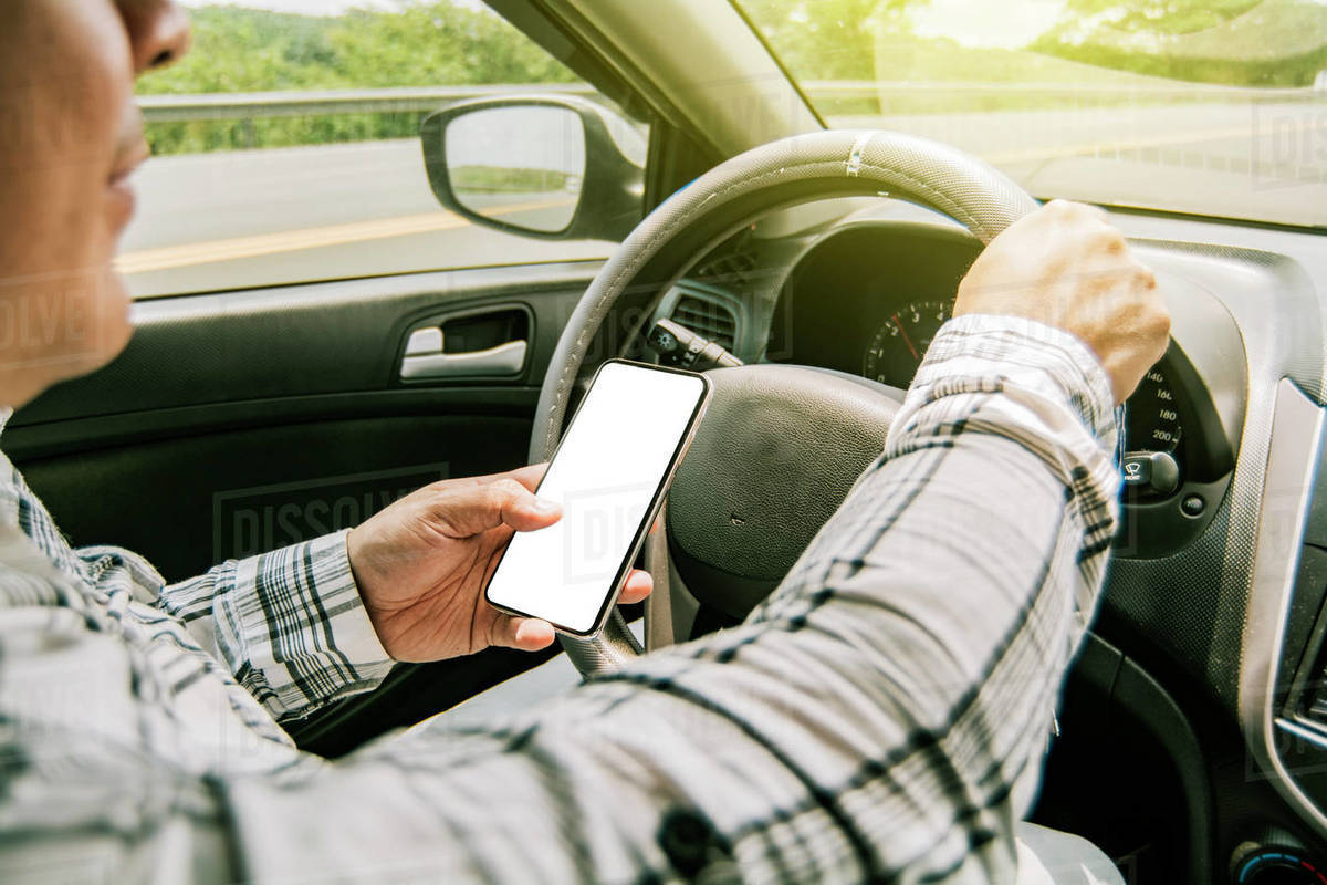 Man using his phone while driving, Person holding the cell phone and ...