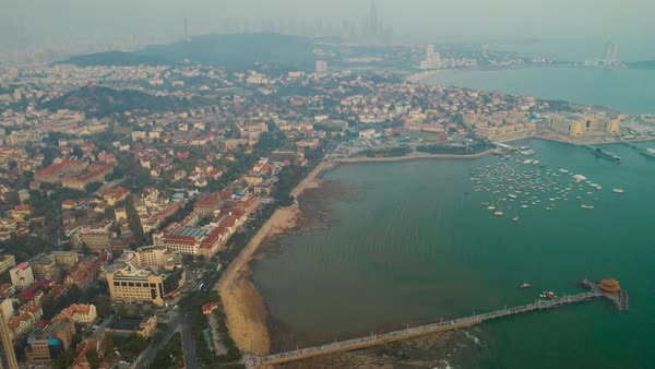 Sunset time qingdao city famous beach bay tourist pier aerial timelapse ...