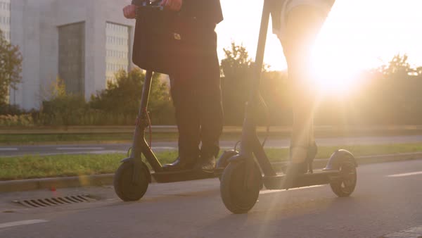 Business people riding electric scooters on street in city - 4K Royalty ...