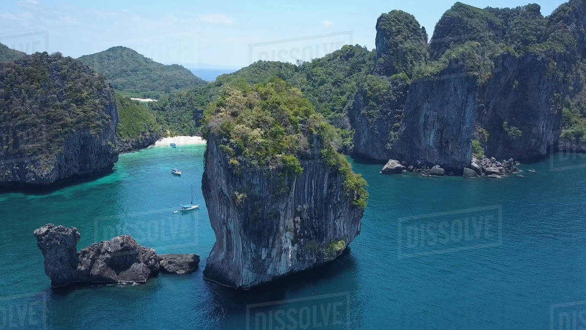 AERIAL: Picturesque flying shot of limestone islet and sandy beach in ...