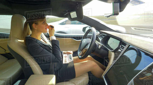 AUTONOMOUS TESLA CAR, MARCH 2018 - CLOSE UP: Stylish woman applying ...
