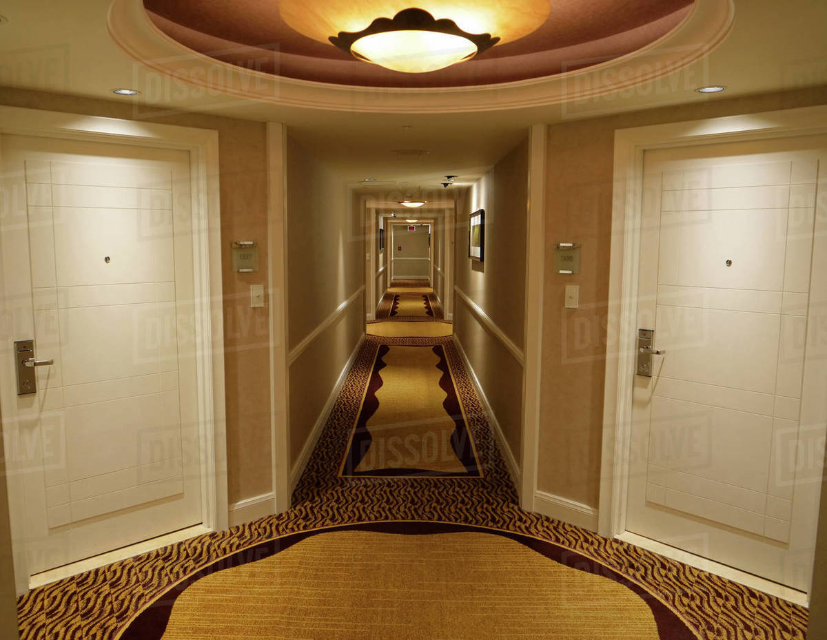 Cool view of a bright and empty corridor of a luxury hotel and closed ...