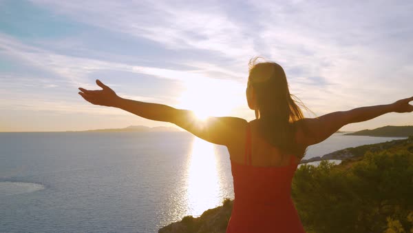 LENS FLARE, CLOSE UP: Summer breeze ruffles woman hair as she raises ...
