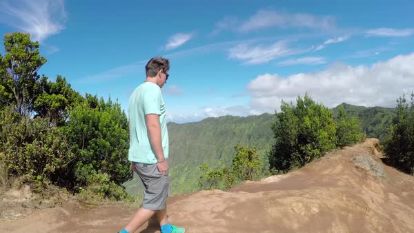 CLOSE UP: Active young man walking along the high mountain ridge in ...