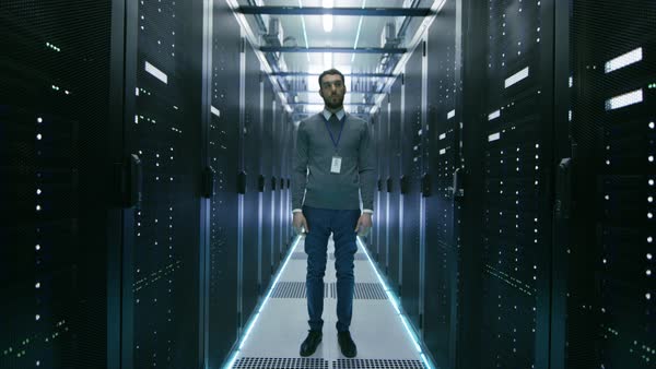 IT engineer standing in the middle of a working data center server room ...