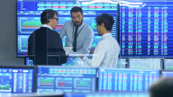 Three experienced stock traders talking business. They work for a big ...