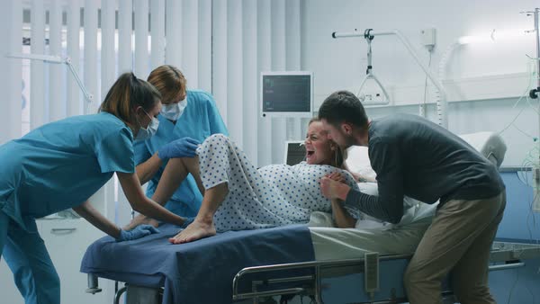In the hospital, woman in labor gives birth, obstetricians and doctors ...