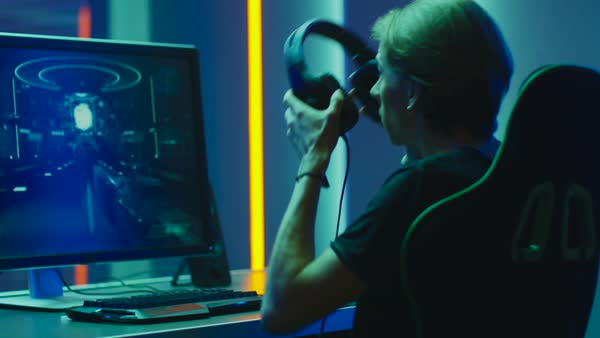 Portrait of the young pro gamer playing in first person shooter online ...