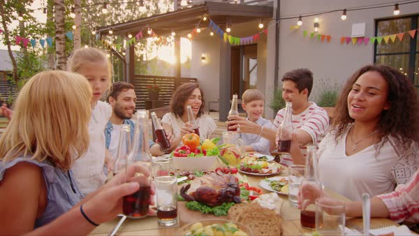 Family and Friends Gathered Together at the Table Raise Glasses and ...