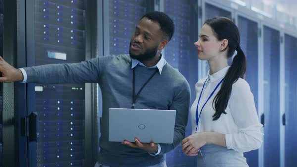Black it technician with a laptop computer gives a tour to a young ...