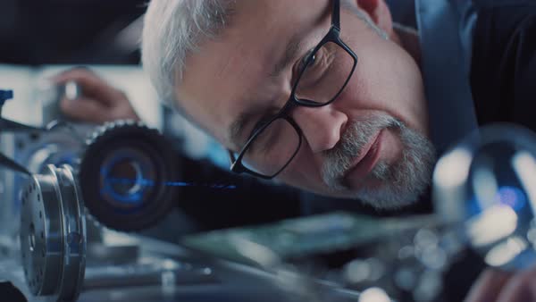 Close-up portrait of focused middle aged engineer in glasses working ...