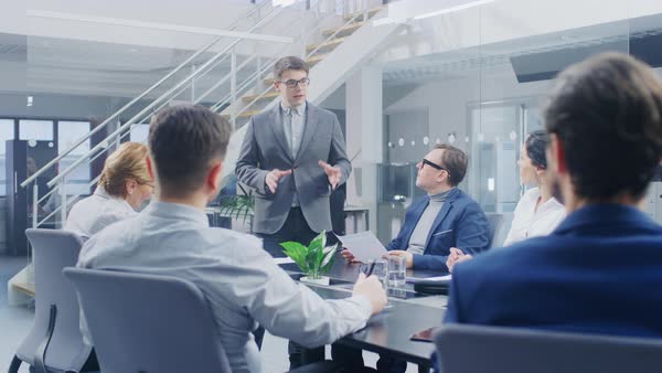 In the corporate office meeting room: chief technology analyst talks to ...