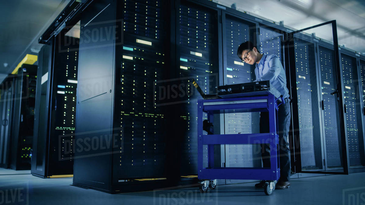 In Data Center: Male IT Technician Running Maintenance Programme on a ...