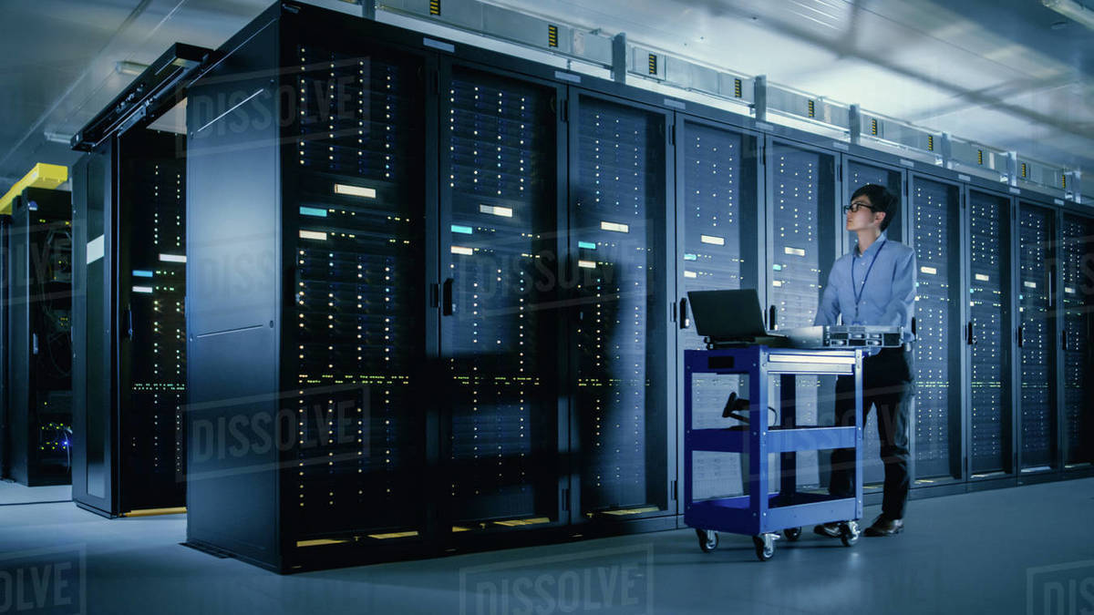 In the Modern Data Center: IT Engineer Doing Maintenance and ...