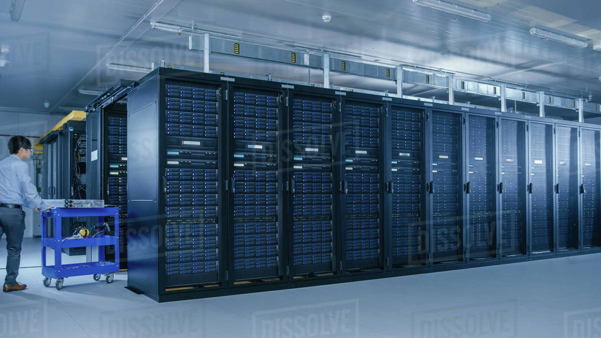 In the Modern Data Center: Team of IT Technicians Working with Server ...