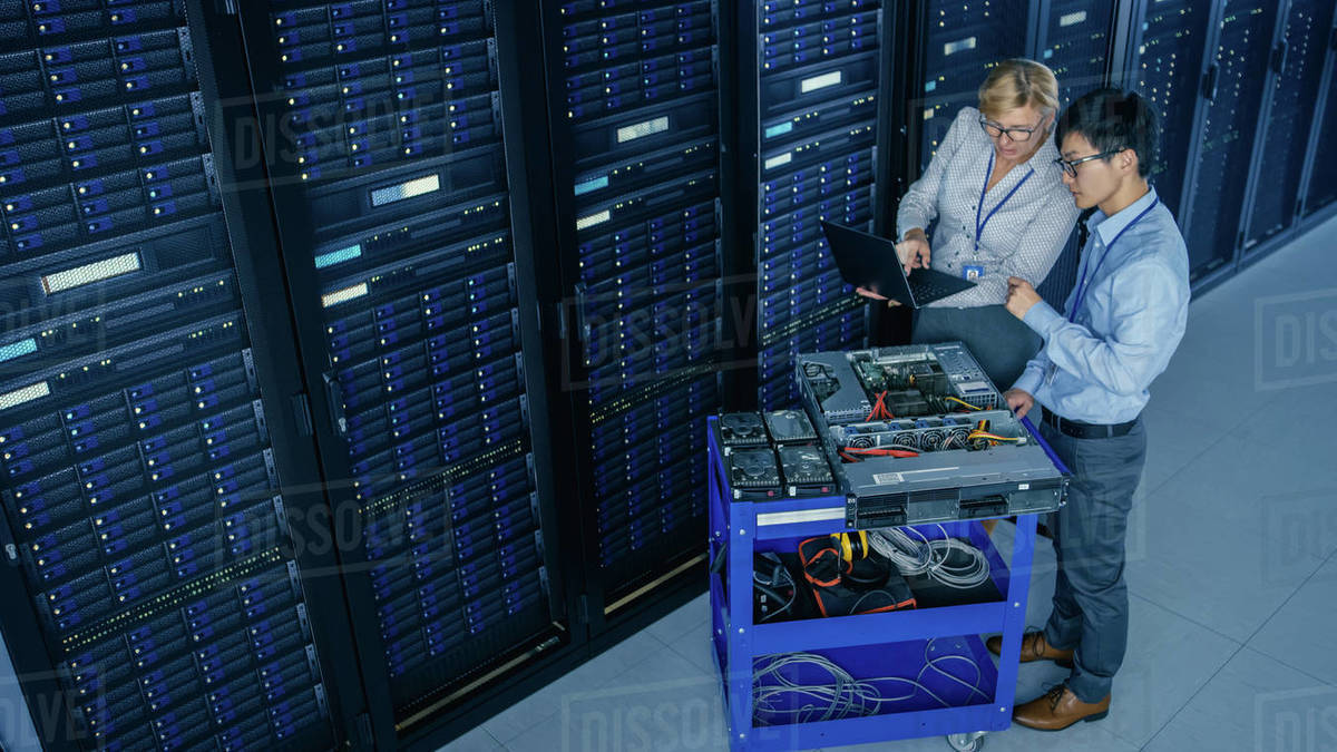 In the Modern Data Center: Engineer and IT Specialist Work with Server ...