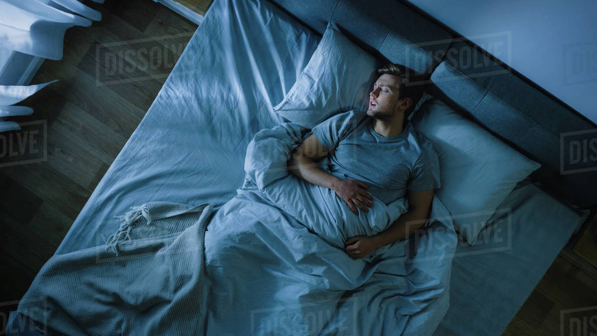 Top View of Handsome Young Man Sleeping Cozily on a Bed in His Bedroom ...