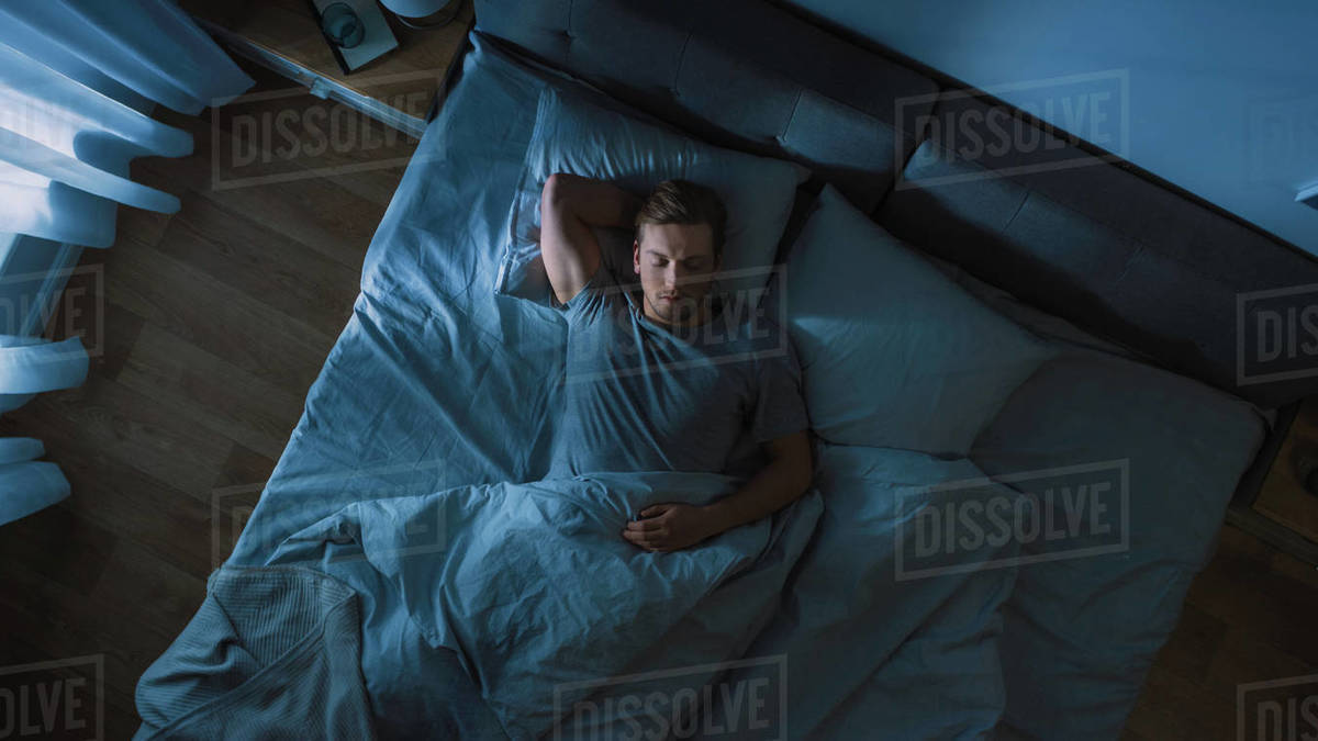 Top View of Handsome Young Man Sleeping Cozily on a Bed in His Bedroom ...