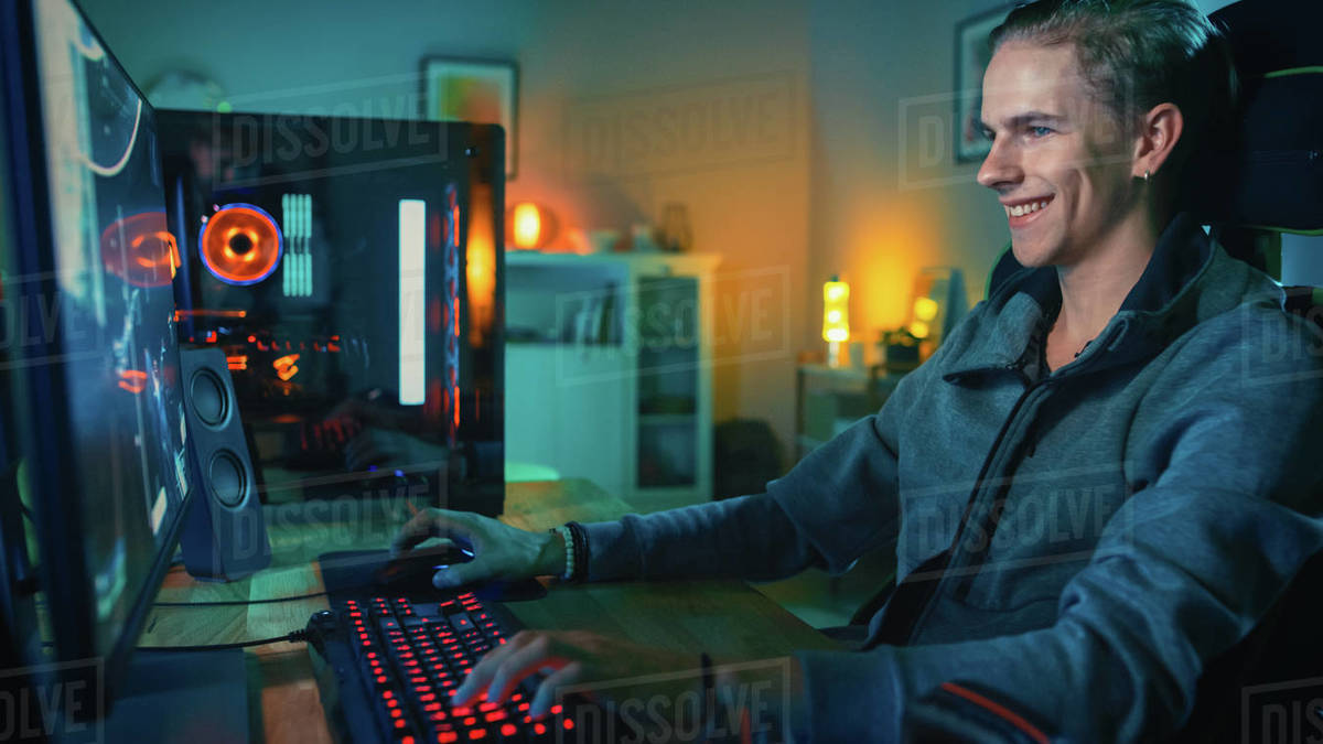 Happy gamer playing first-person shooter online video game on his ...