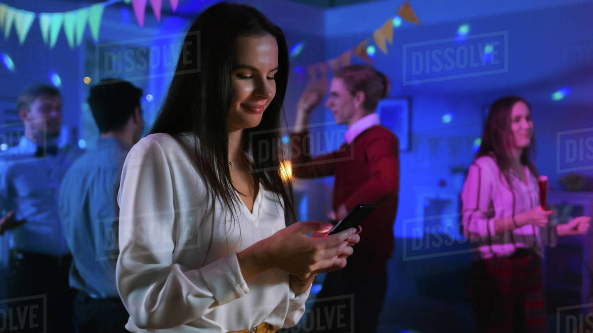 A girl checks her phone at a college party. - Royalty-free Stock Photo ...